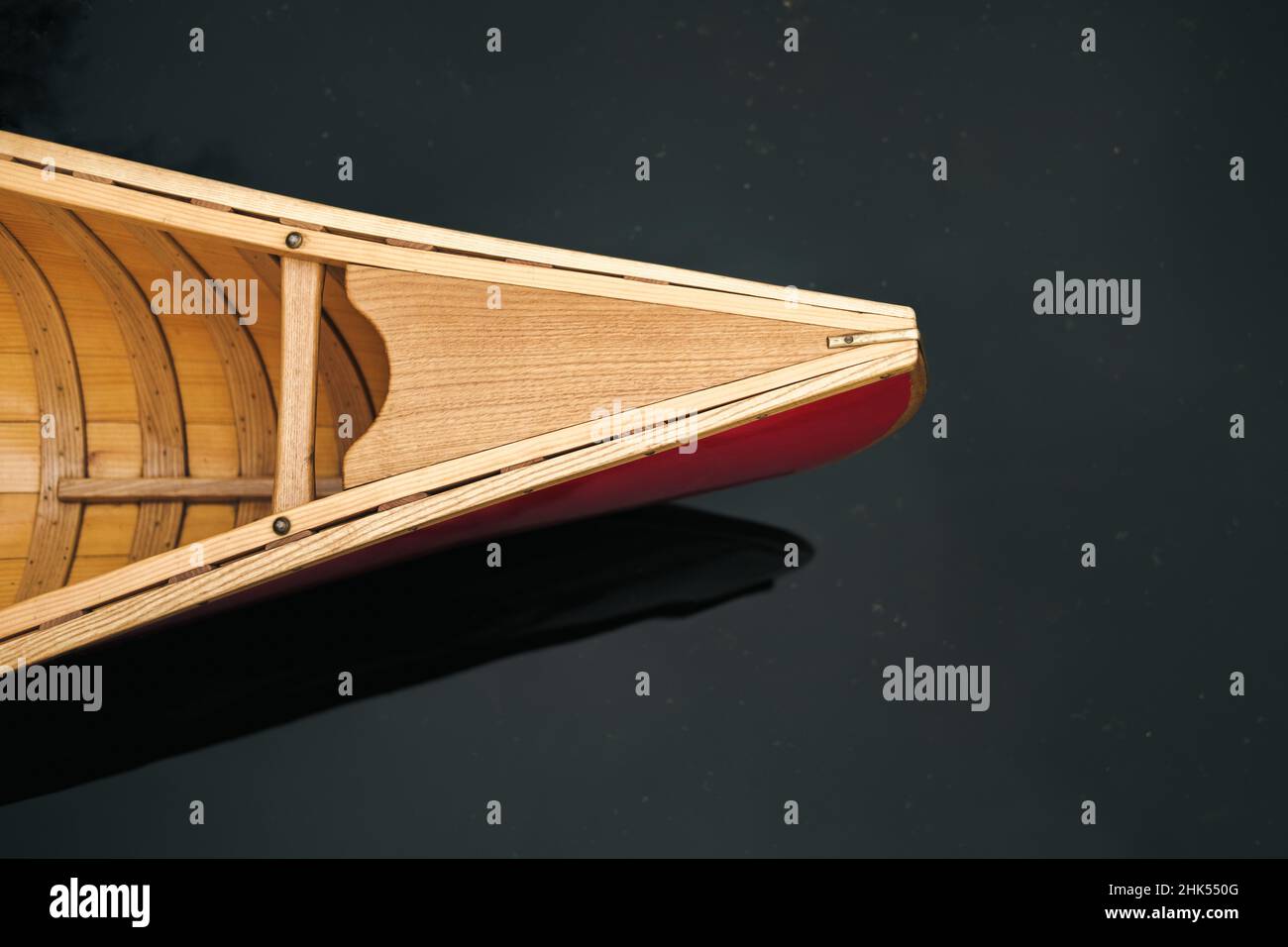 Bow (nose) of a canadian canoe, top view. Wood canoe boat on dark water ...