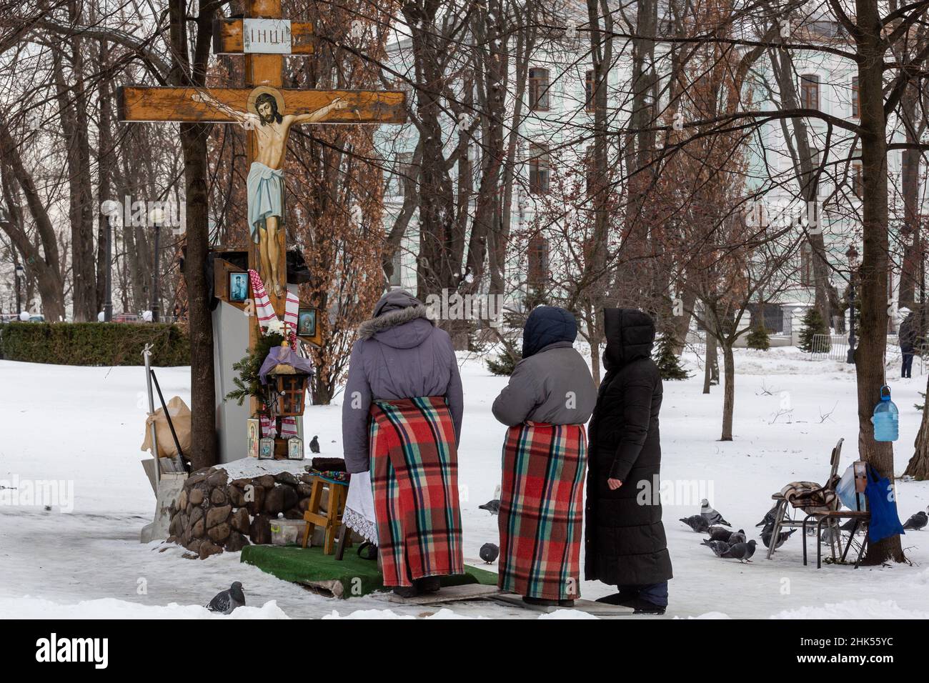 Kiev, Ukraine. 01st Feb, 2022. Women pray by a cross in Maryjskij Park ...