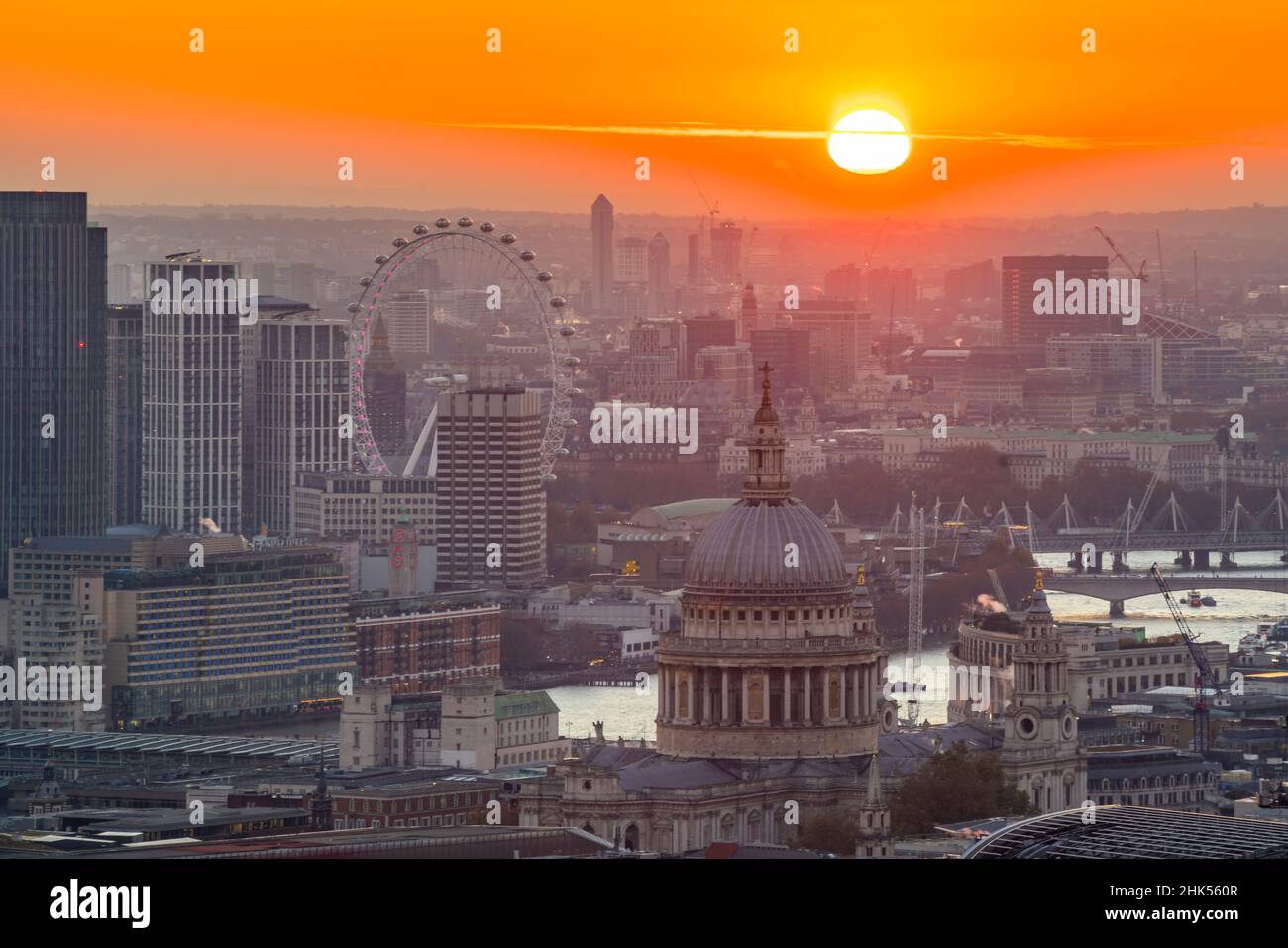 View of sun setting over London Eye and St. Paul's Cathedral from the ...