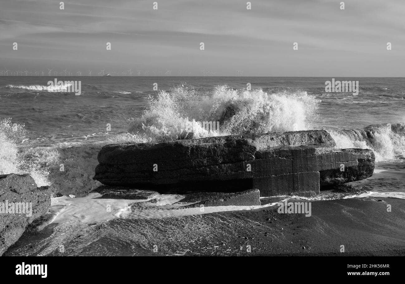 Big waves crashing over rocks on a beach Stock Photo - Alamy