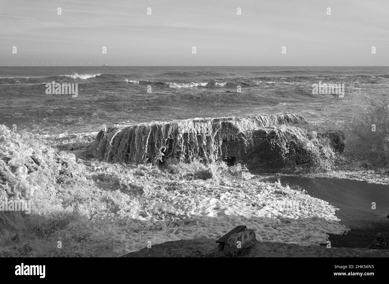 Big waves crashing over rocks on a beach Stock Photo - Alamy