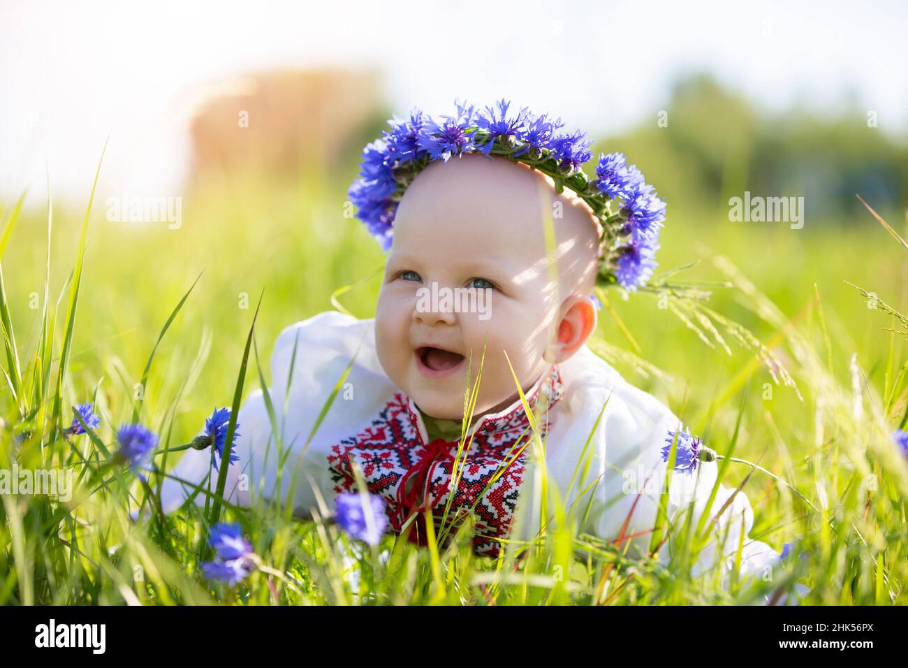 A happy little girl in national Belarusian or Ukrainian clothes lies on ...