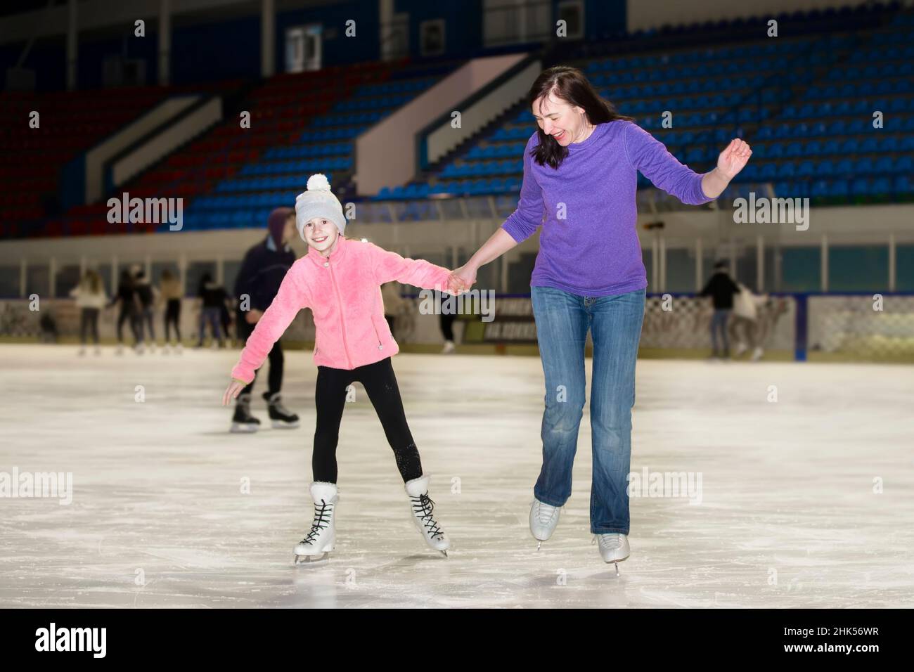 Mom and daughter are skating on the ice arena Stock Photo - Alamy