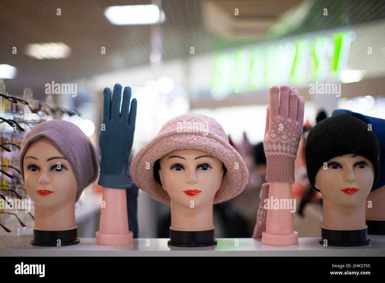 In the store, there are mannequin heads in knitted hats and gloved ...