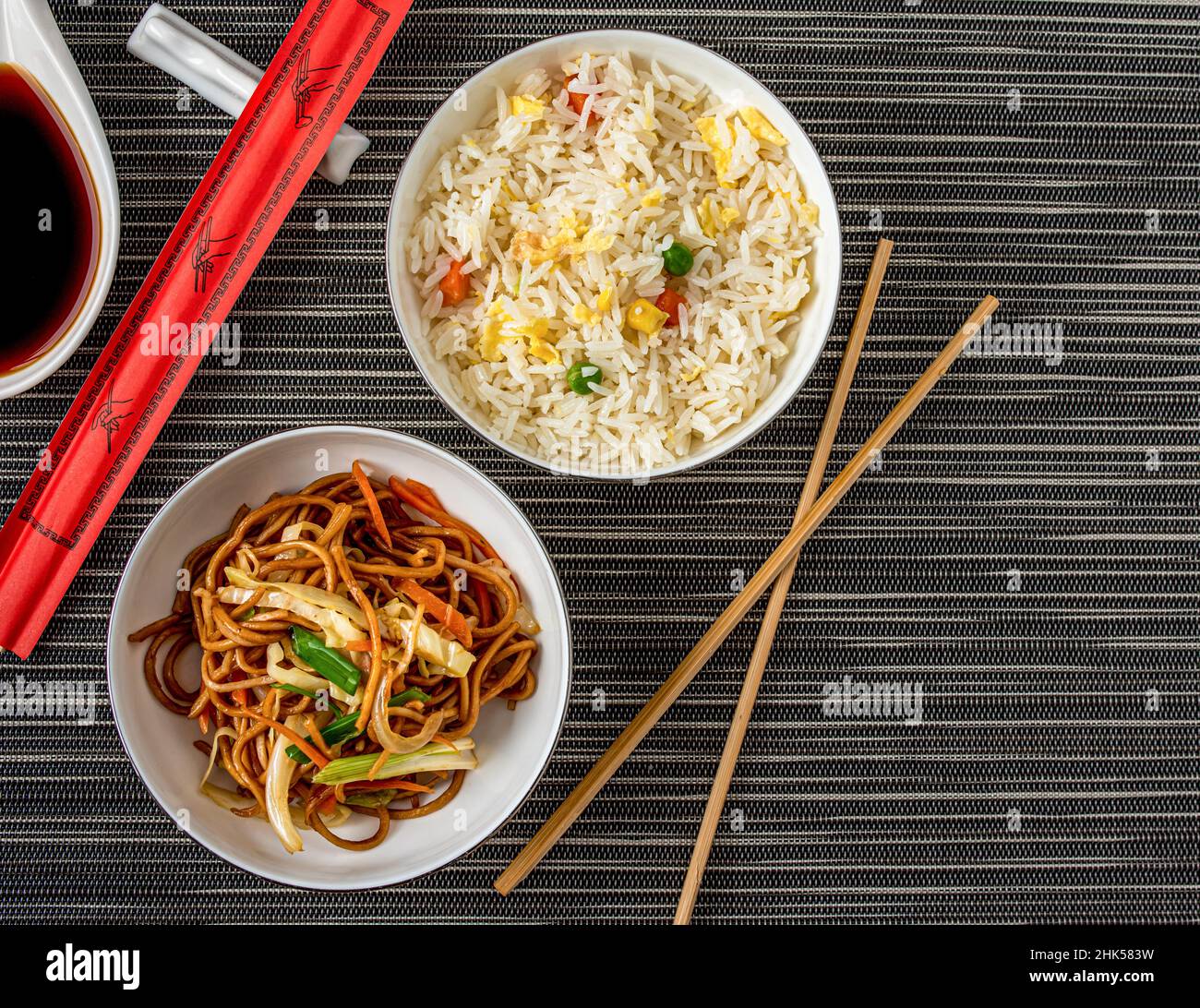 Noodles with vegetables and rice pilaf with egg and corn in a white ...