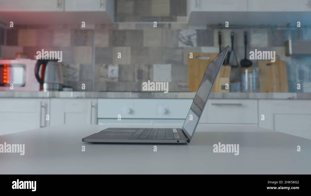 Hands open laptop on kitchen. Action. Young man opens laptop at kitchen ...