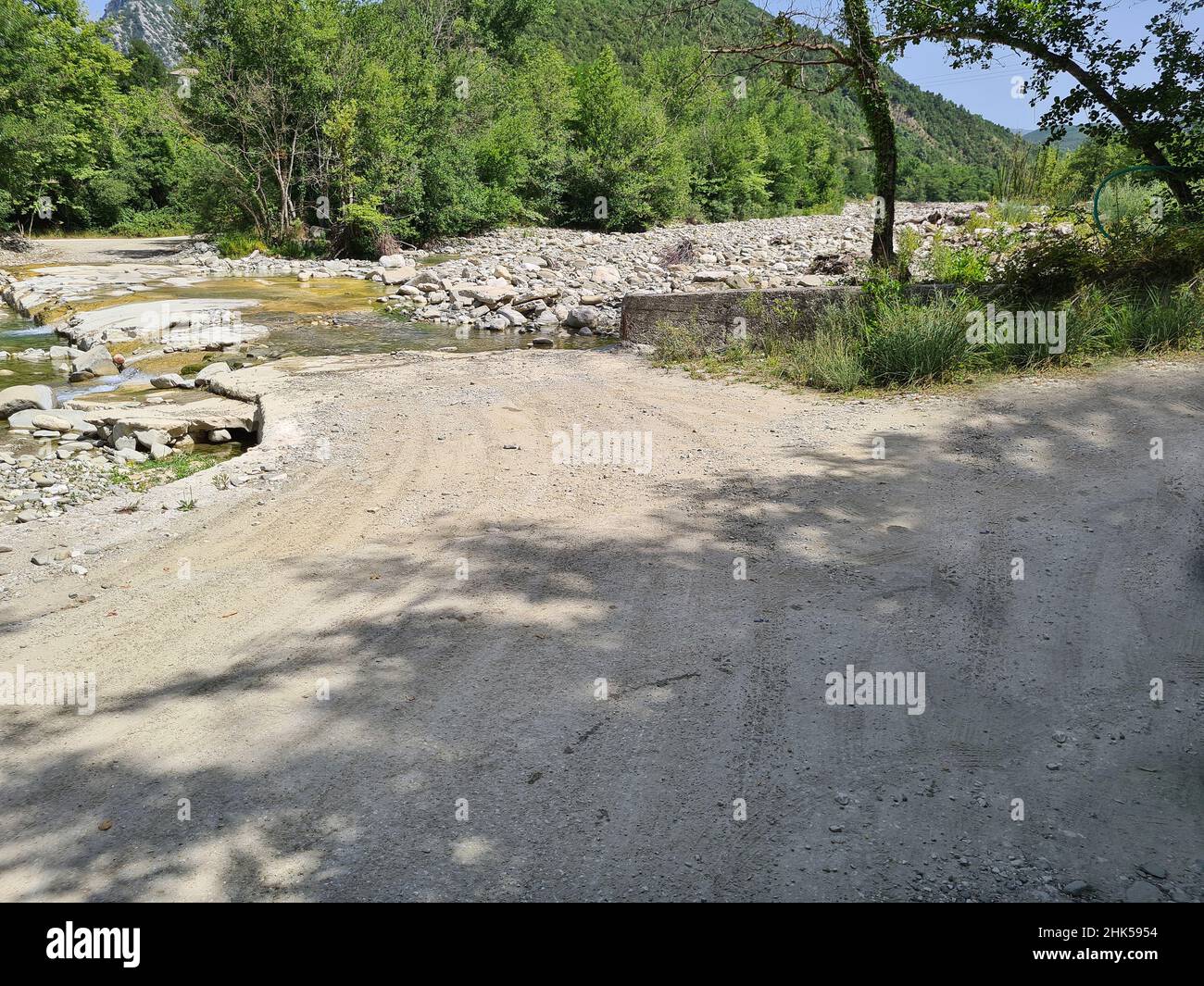Greece, end of road, boulder and stones in the river bed , a branch of ...