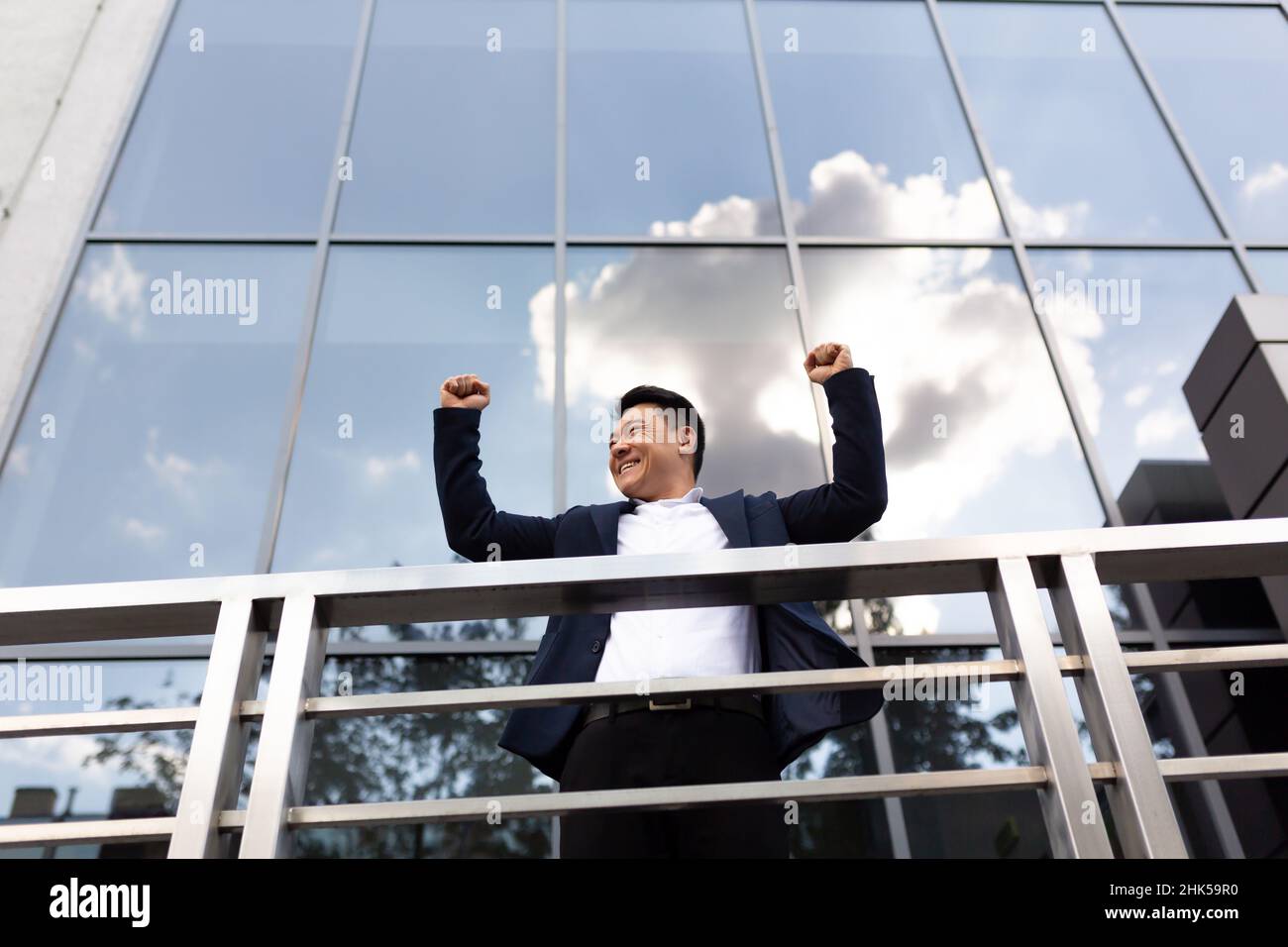 Asian businessman boss stands near his office center on the balcony in ...