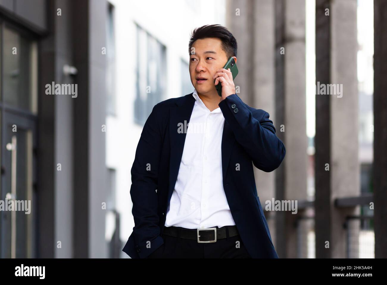 Asian businessman talking on the phone serious has an angry ...