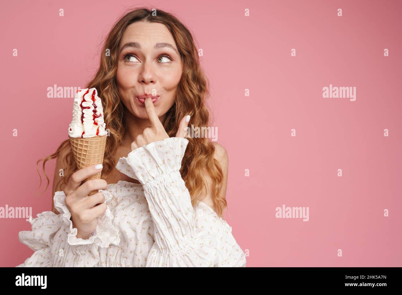 Young Ginger Woman Licking Her Finger While Eating Ice Cream Isolated