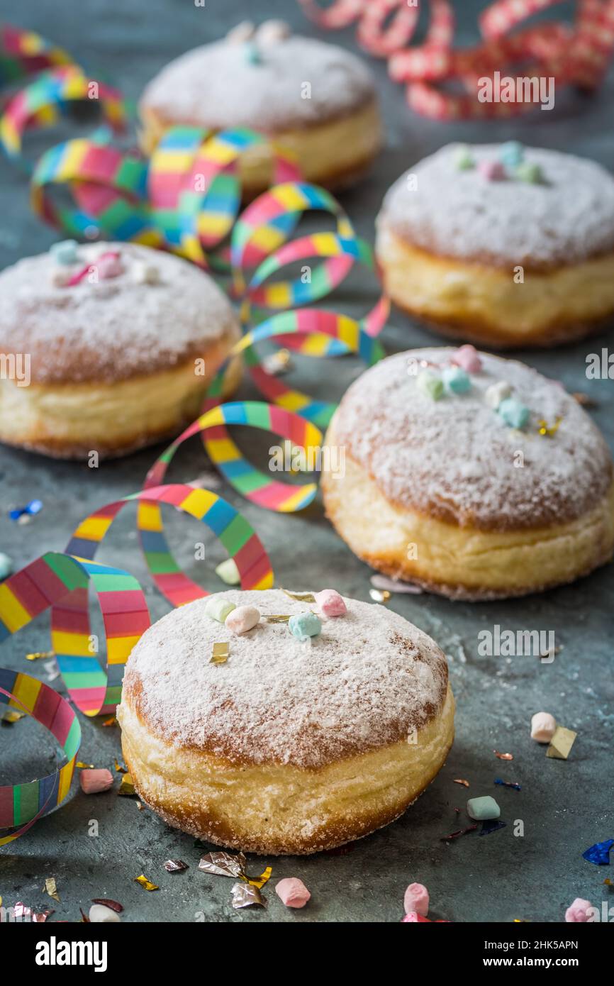 Krapfen, Berliner or donuts with streamers, confetti and mini ...