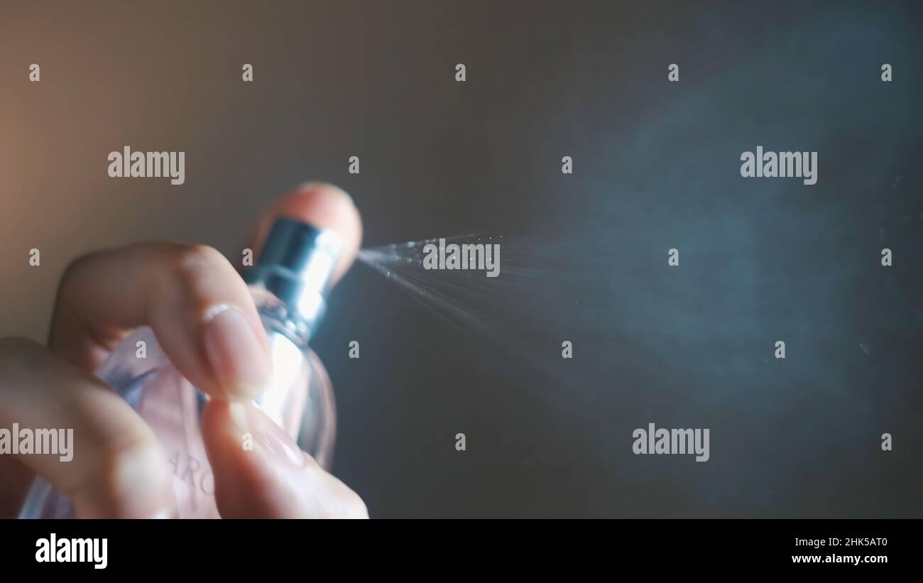 Close up of woman hands spraying perfum. Bottom view of woman hand ...
