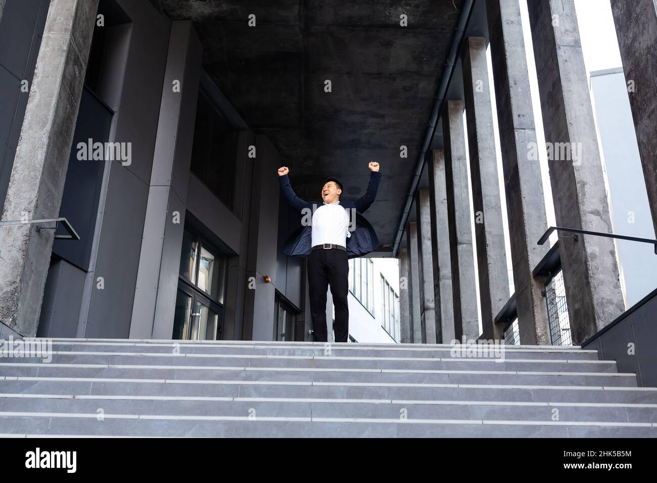 Happy and cheerful asian businessman holding hands up rejoicing in ...