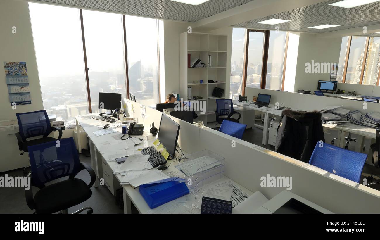 View of business office with one employee sitting at work alone. View ...