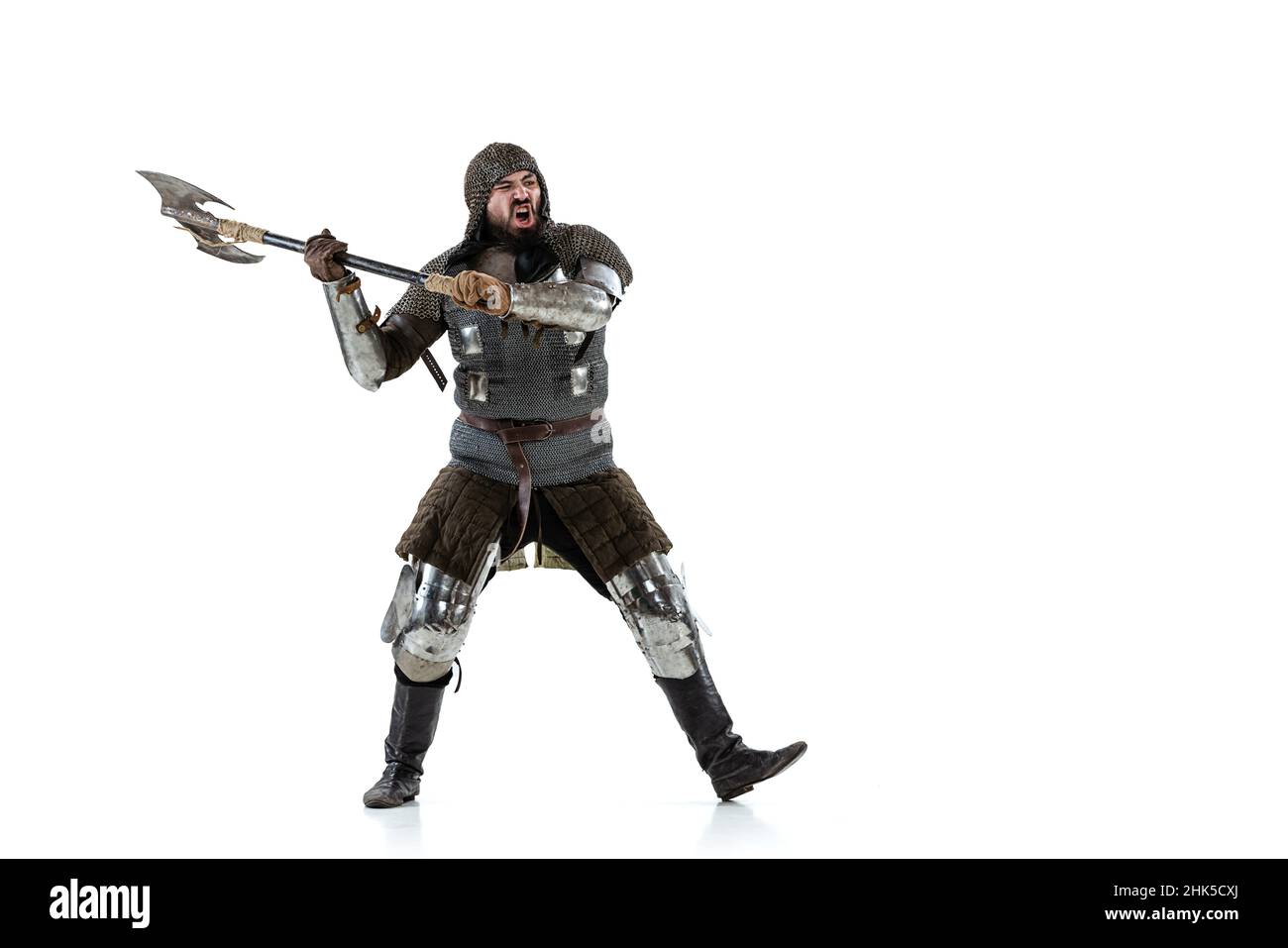 Full-length portrait of brutal serious man, medieval knight swinging ax ...
