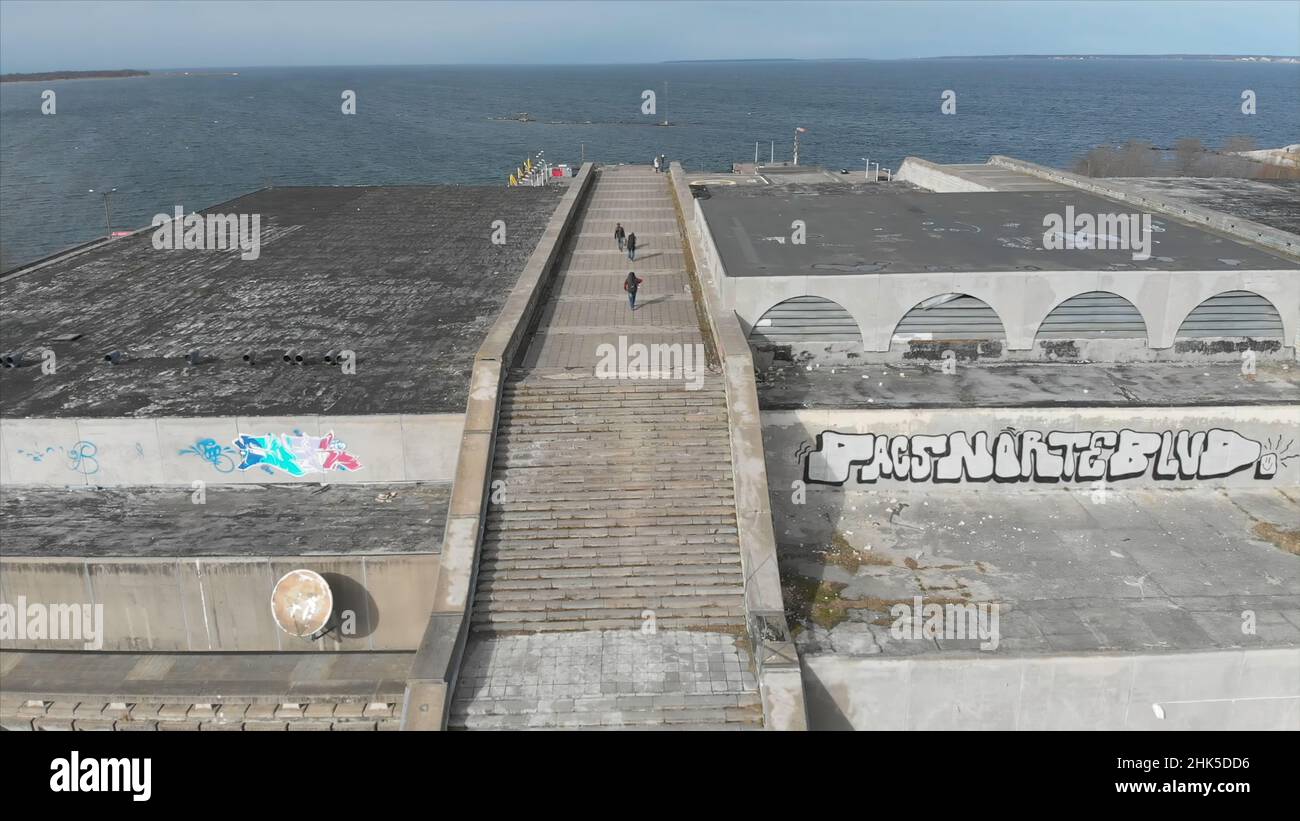 Aerial view of a small empty sea port. Flying over people walking on ...