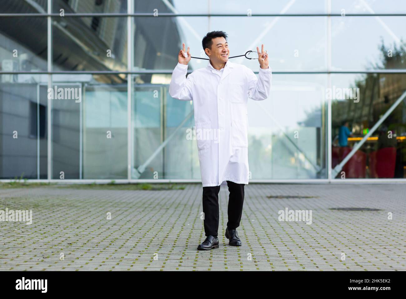 portrait of a cheerful Asian doctor man dancing happy with the results ...
