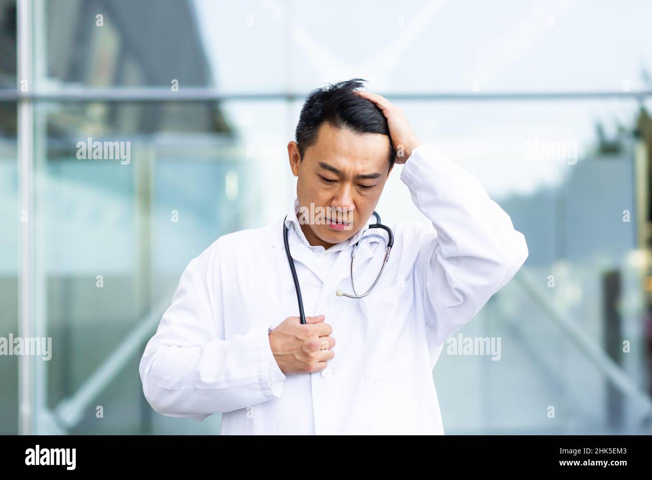 Asian doctor is tired after work, depressed and disappointed with the ...