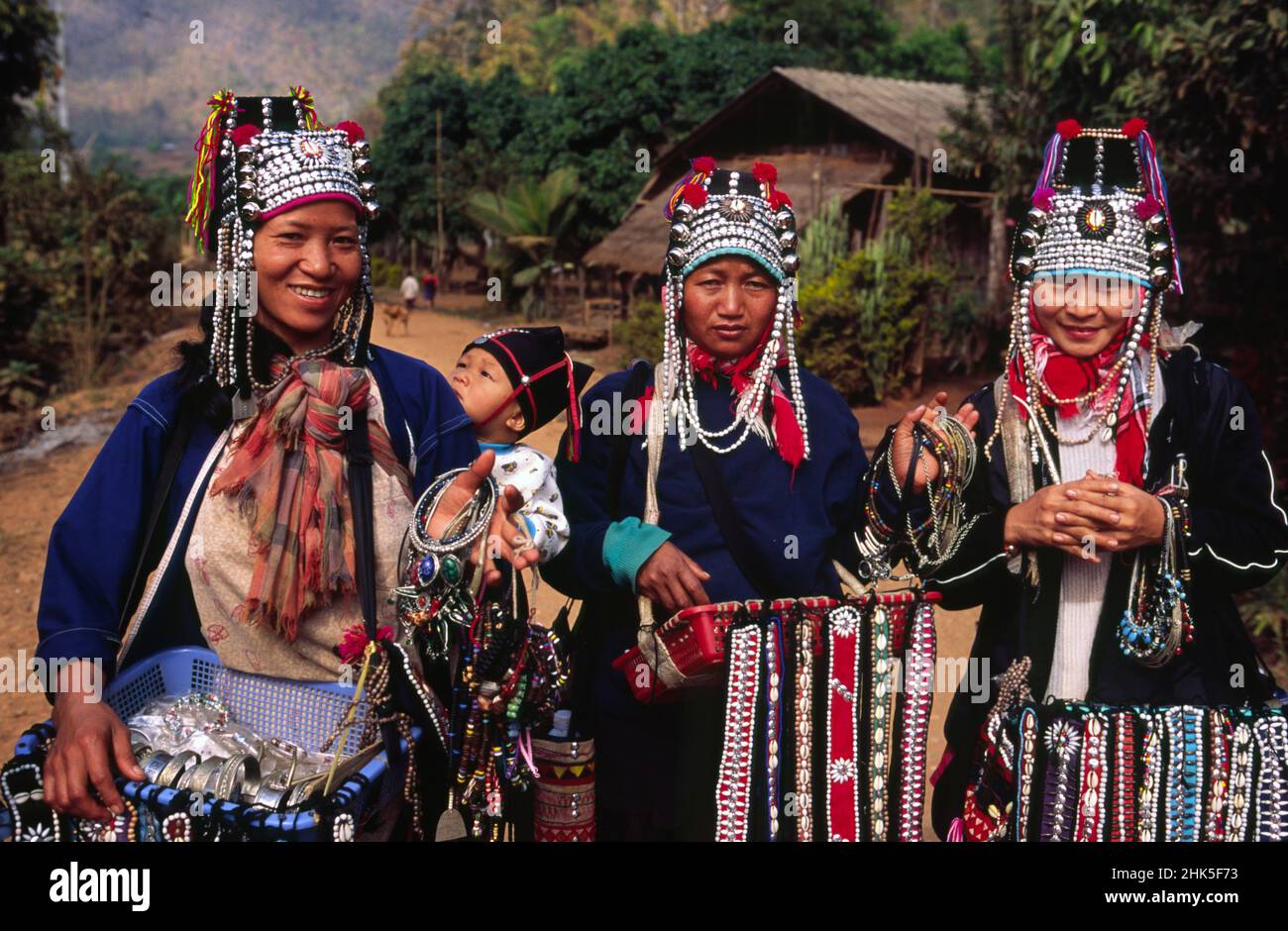 Three Akha women - and a baby - in traditional costume. The Akha are an ...
