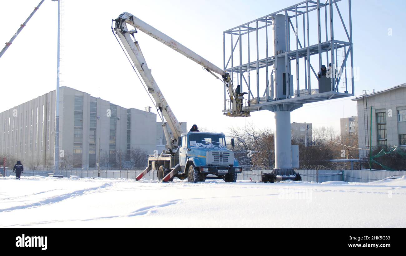 Builder on a Lift Platform at a construction site. Men at work ...