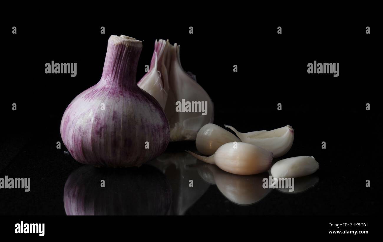 Delicious beautiful garlic on black background. Frame. Concept of a ...