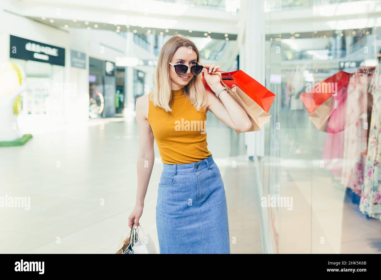 Beautiful woman looks shop window hi-res stock photography and images ...
