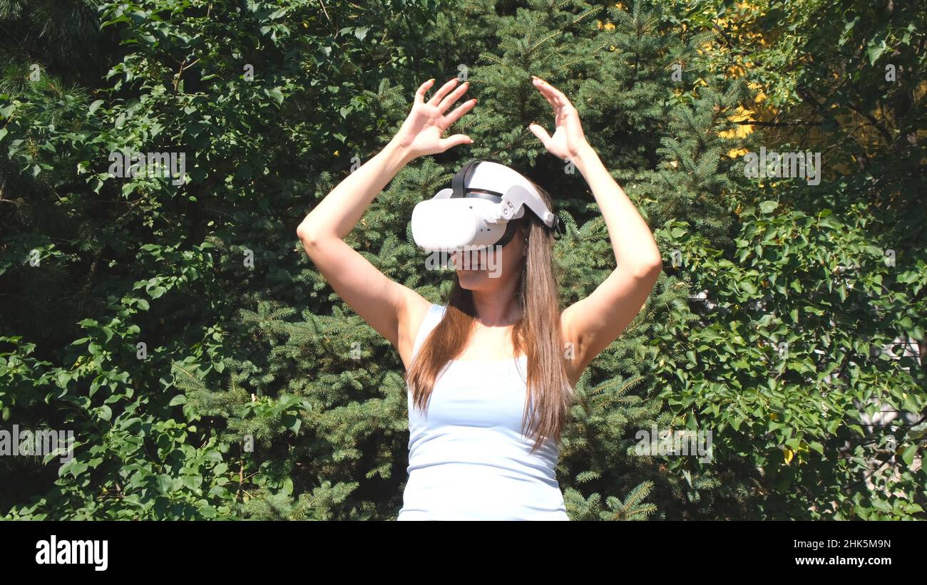 Female wearing virtual reality glasses dances against the background of ...