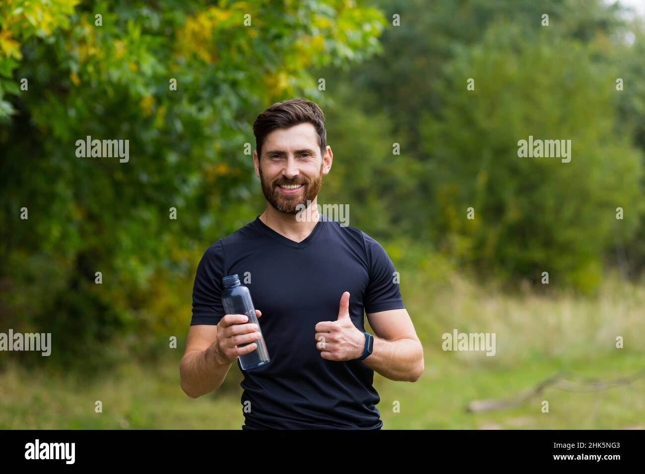 Tired exhausted dehydrated Athlete man runner drinking water bottle ...