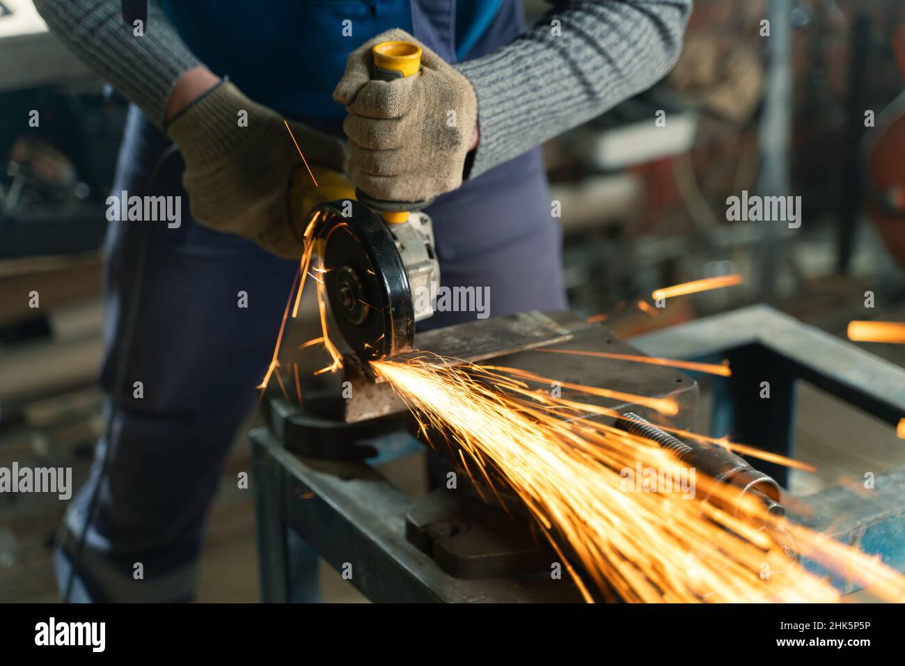 Locksmith in special clothes and goggles works in production. Metal ...
