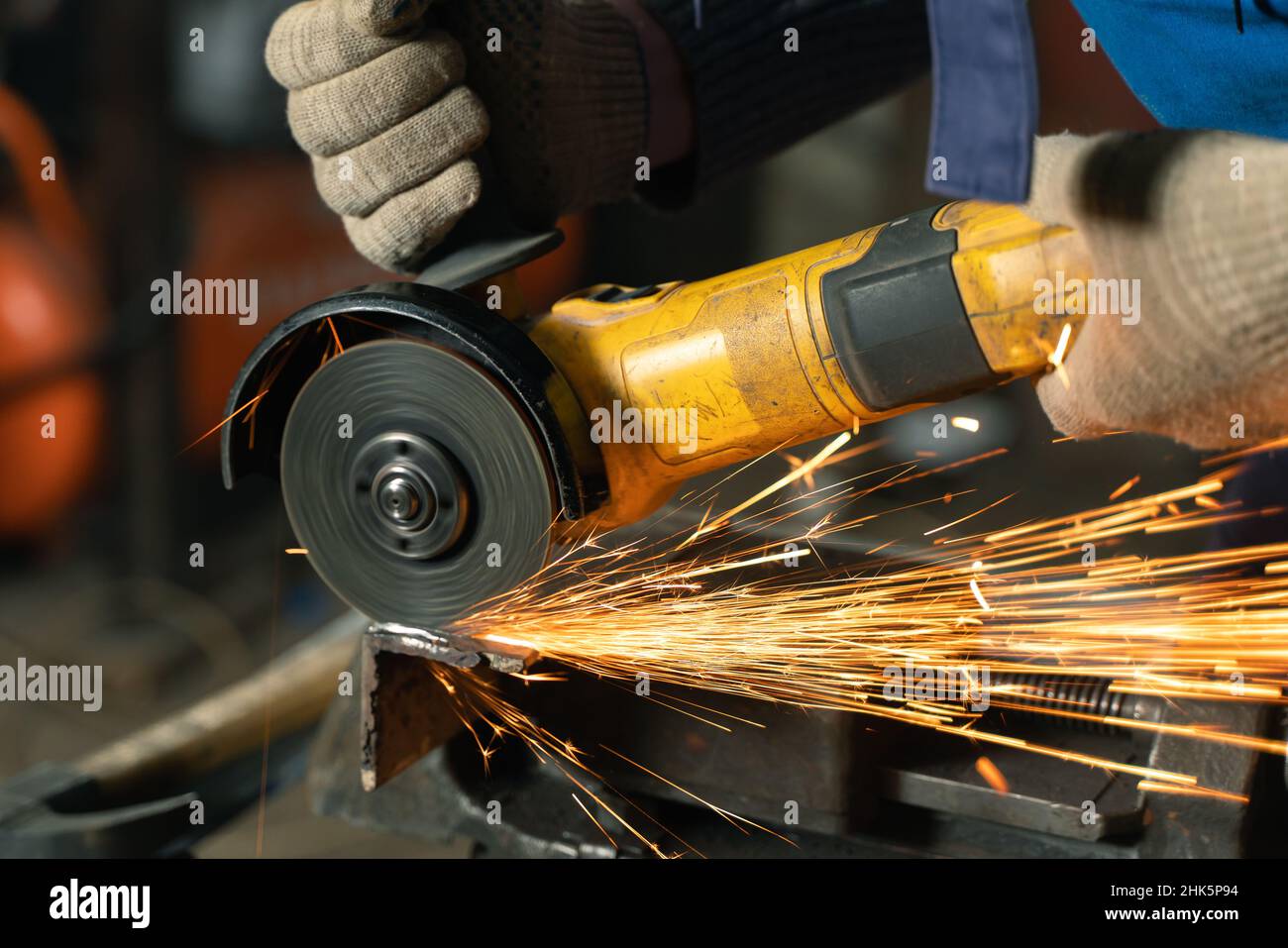 Locksmith in special clothes and goggles works in production. Metal ...