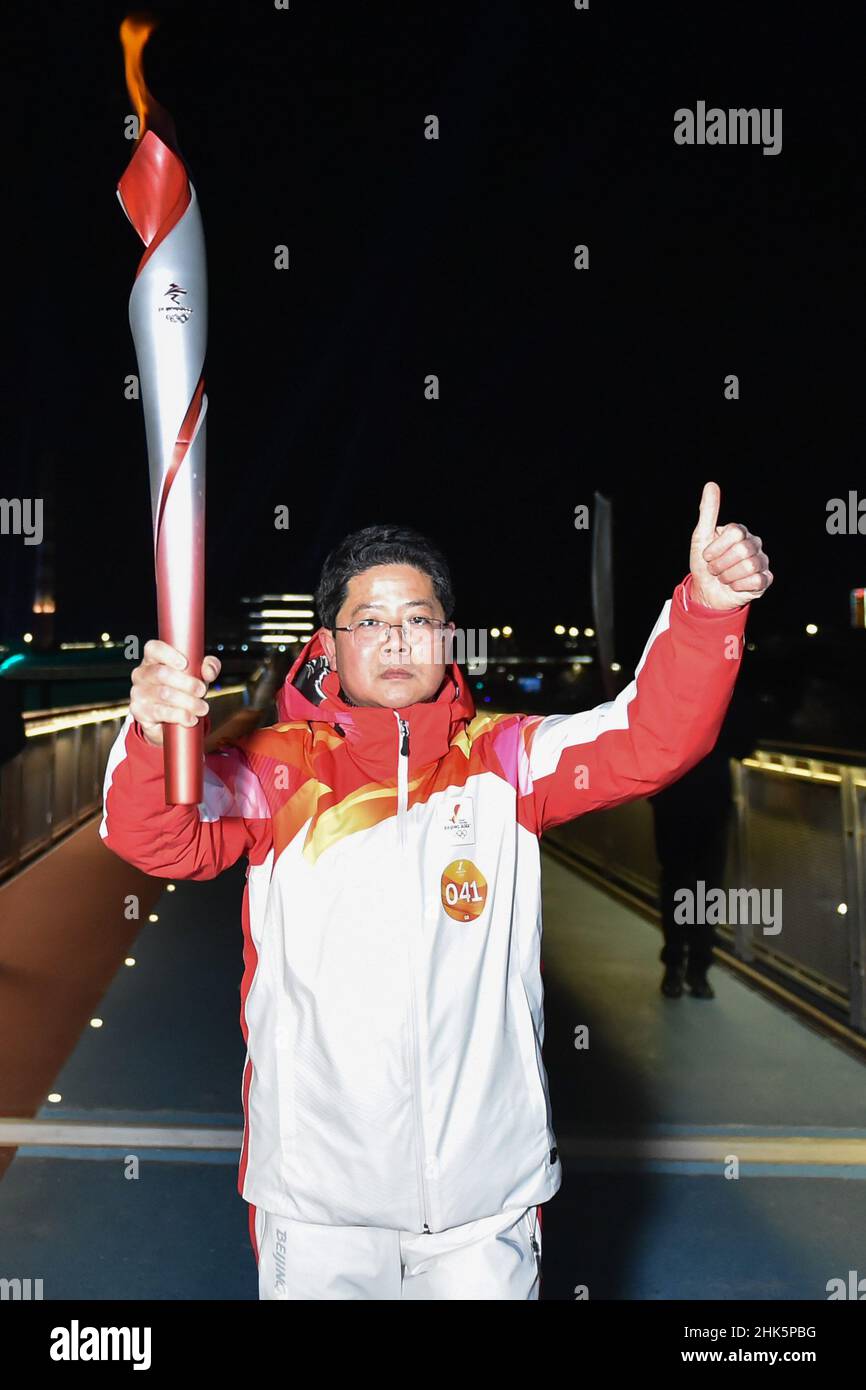 Beijing, China. 2nd Feb, 2022. Torch bearer Li Zhengjun runs with the torch during the Beijing ...