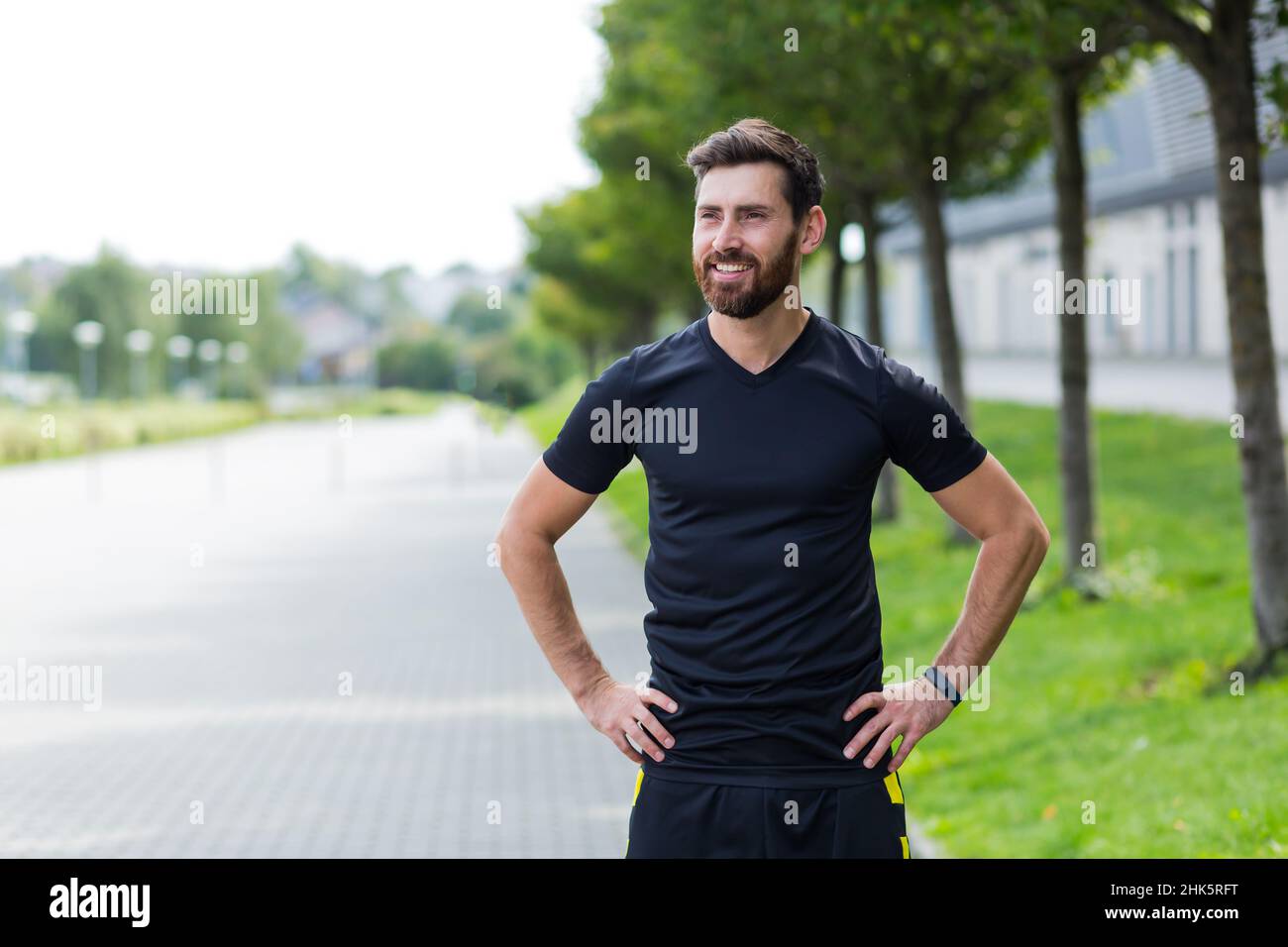 Close up portrait young happy bearded man standing in nature between ...