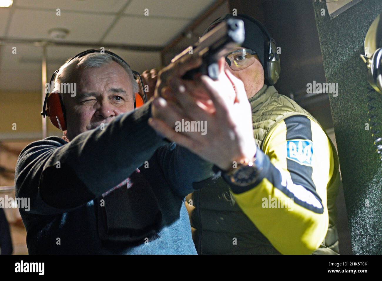 LVIV, UKRAINE - FEBRUARY 1, 2022 - An instructor helps a man point a ...