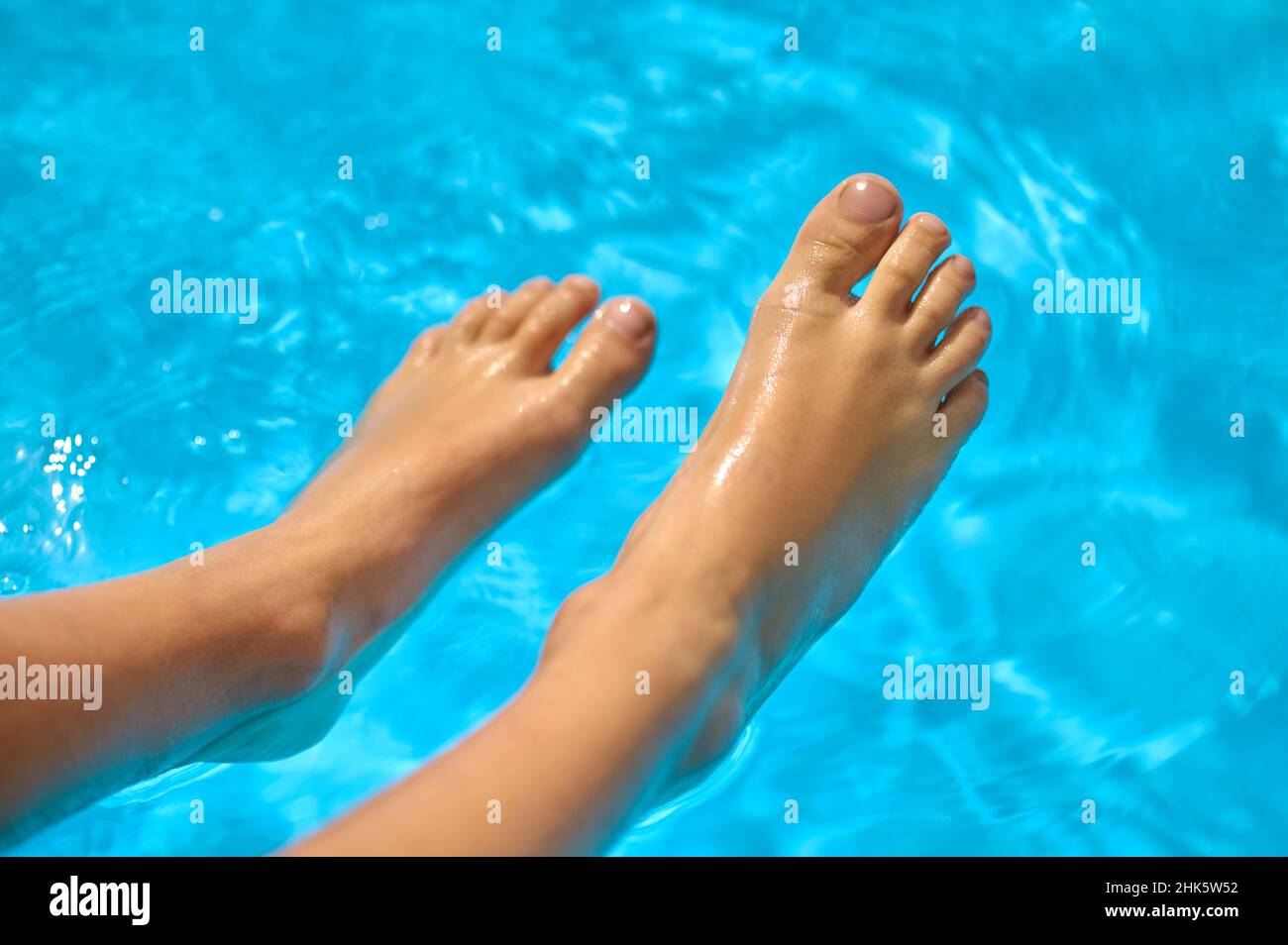 Childrens feet above water surface of pool Stock Photo - Alamy