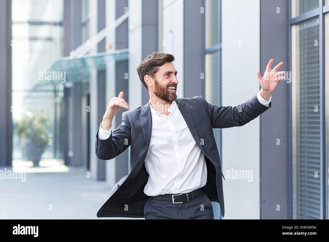 Cheerful happy business man dancing walk the city street background a ...