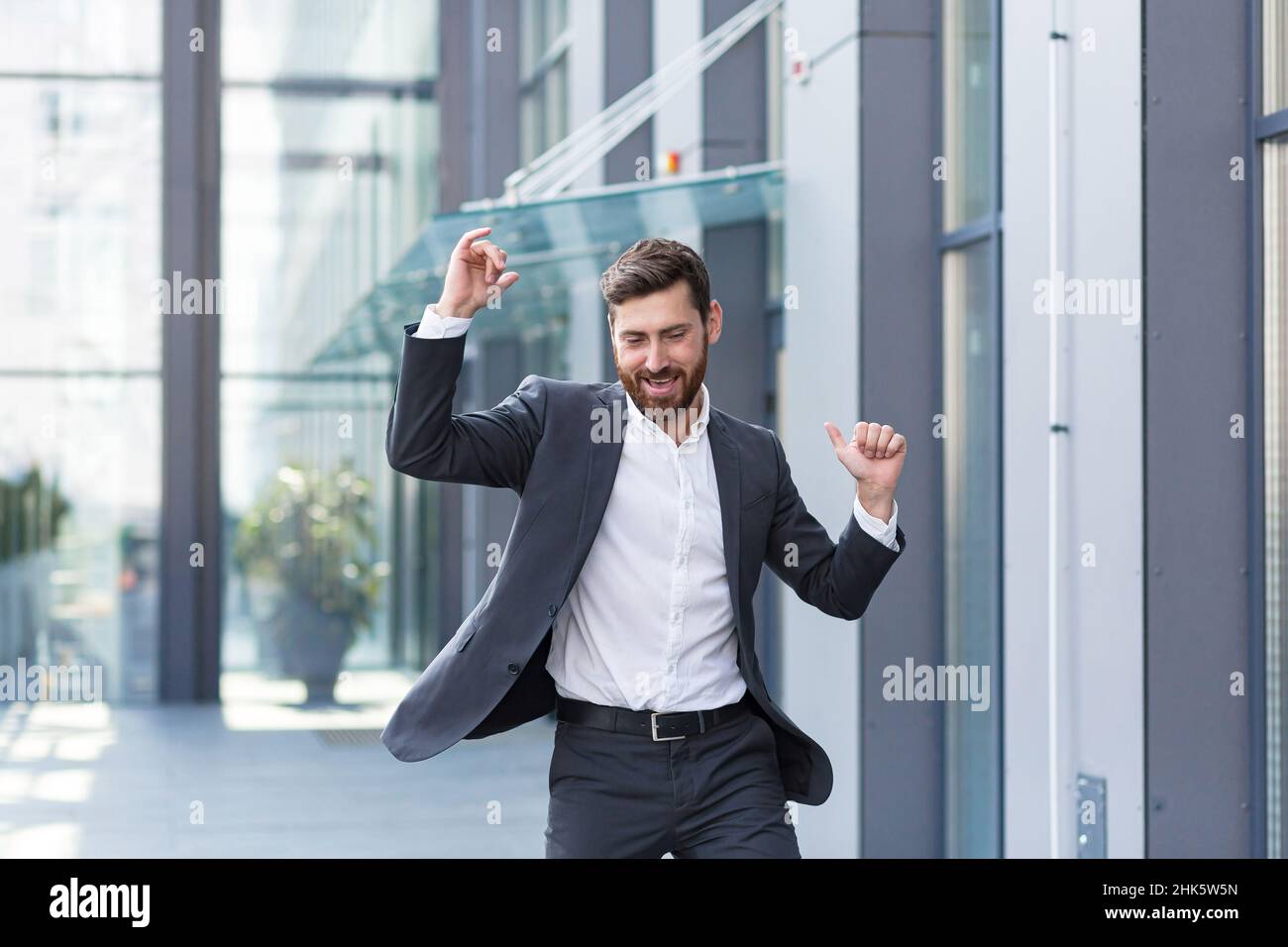 Cheerful happy business man dancing walk the city street background a ...