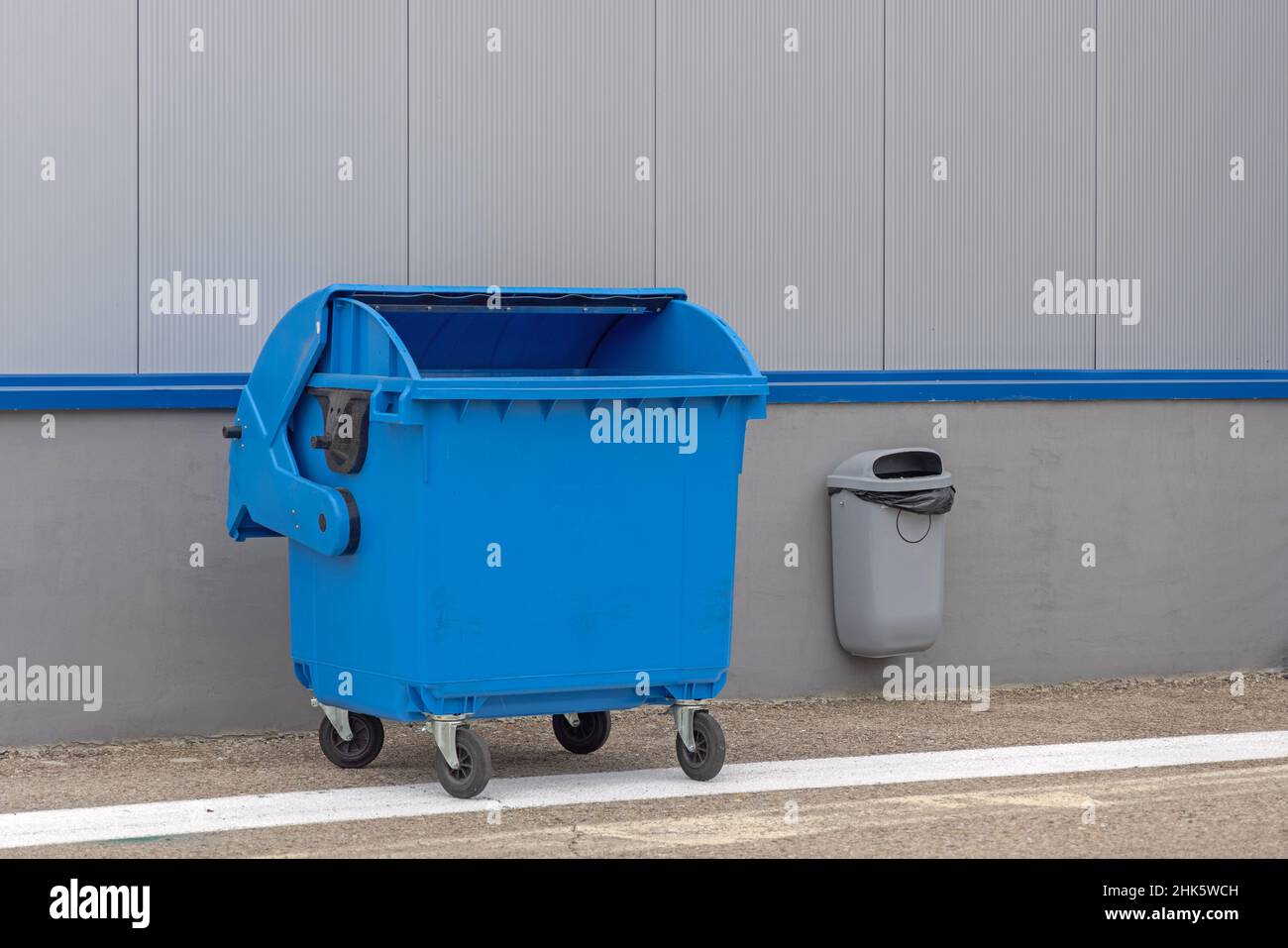 Open Blue Wheeled Dumpster and Hanging Trash Bin Warehouse Stock Photo ...