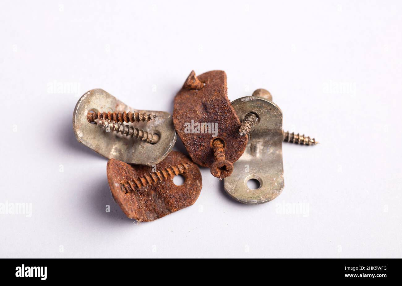 metal angle brackets with corrosive rust and damaged screws, white ...