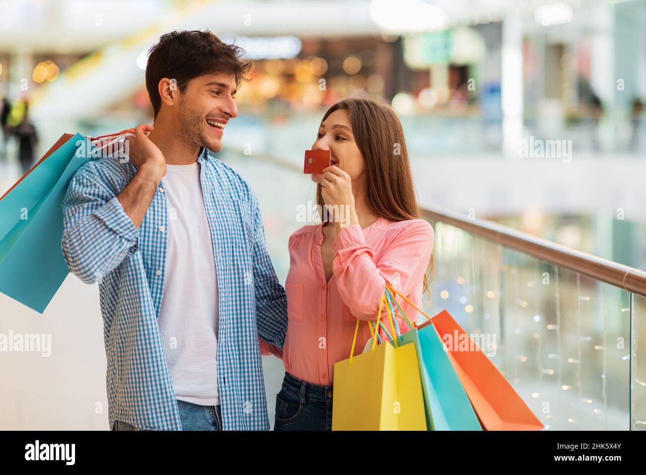 Couple Shopping, Wife Showing Credit Card Carrying Bags In Mall Stock ...