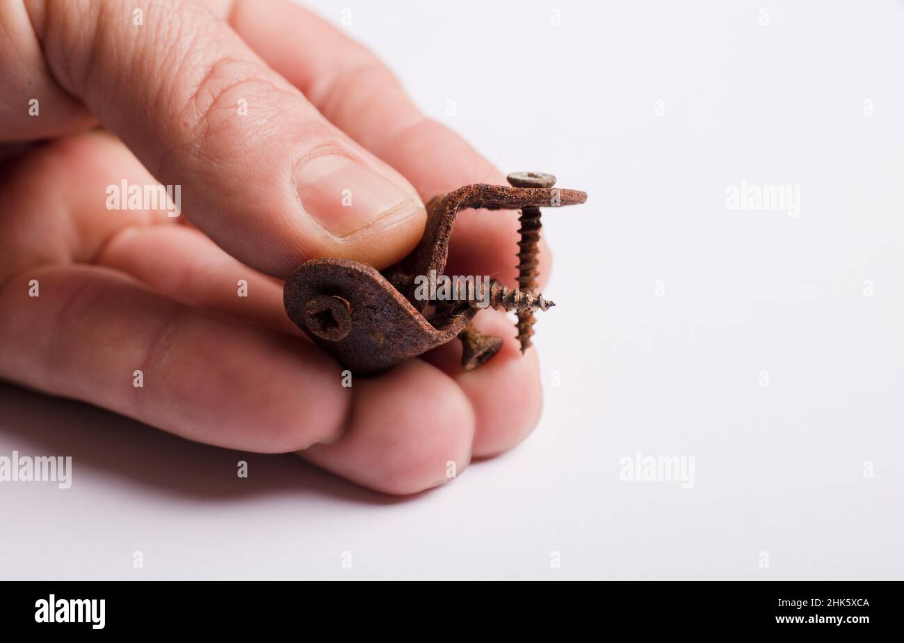angle brackets with corrosive rust in man's hand, oxide, white ...