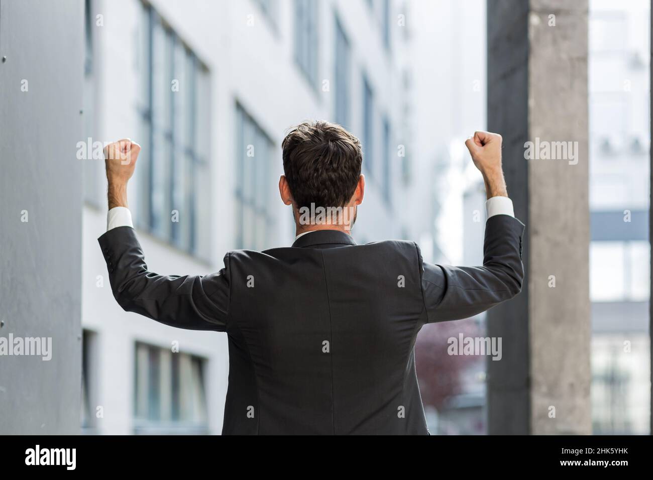 Successful Caucasian businessman with arms up celebrating victory ...