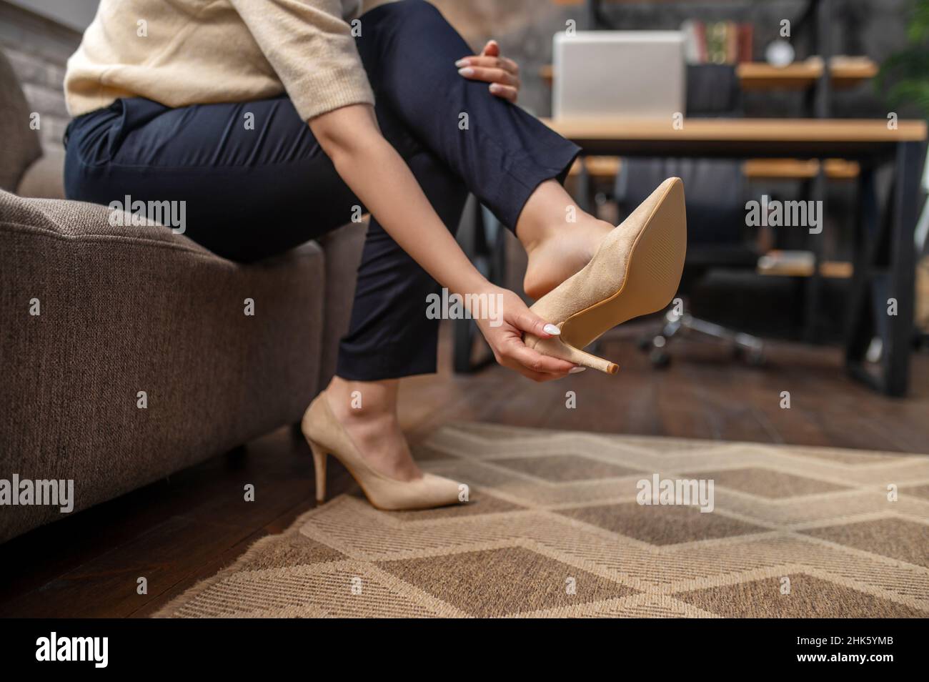 Female pulling off stylish high-heeled shoes on the rug Stock Photo - Alamy