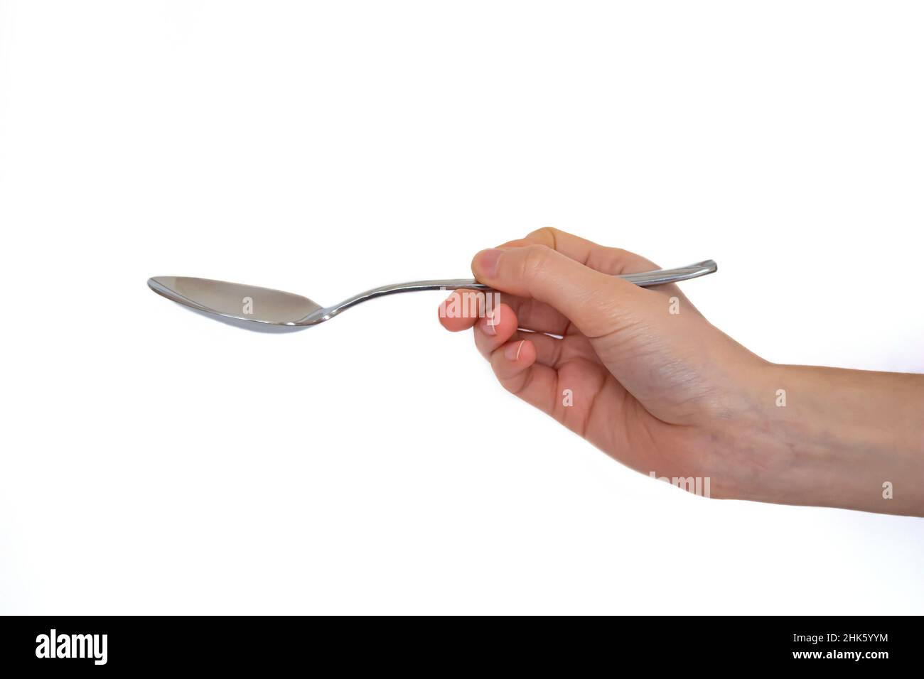 Hand holding metal spoon isolated on white background Stock Photo - Alamy