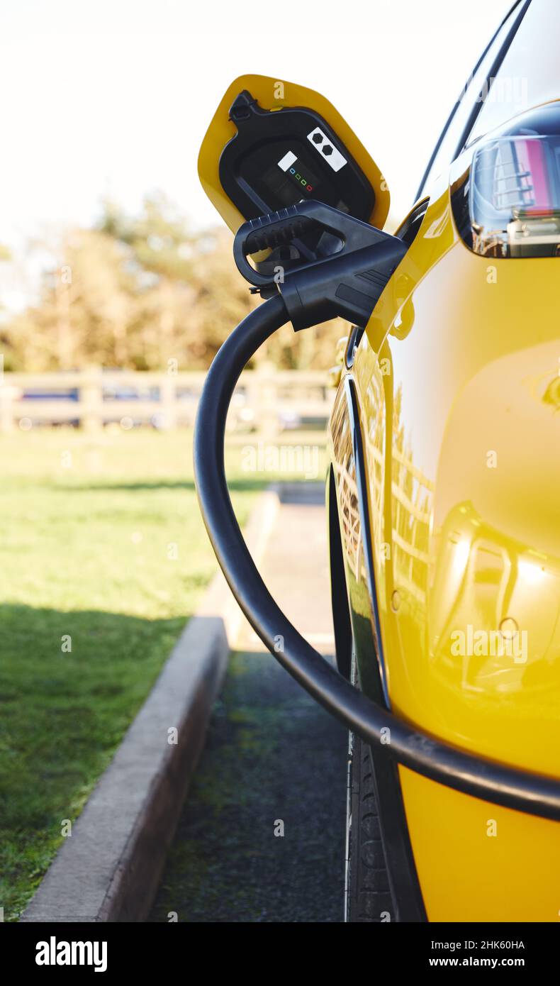 Close up of power supply plugged into an electric car being charged ...