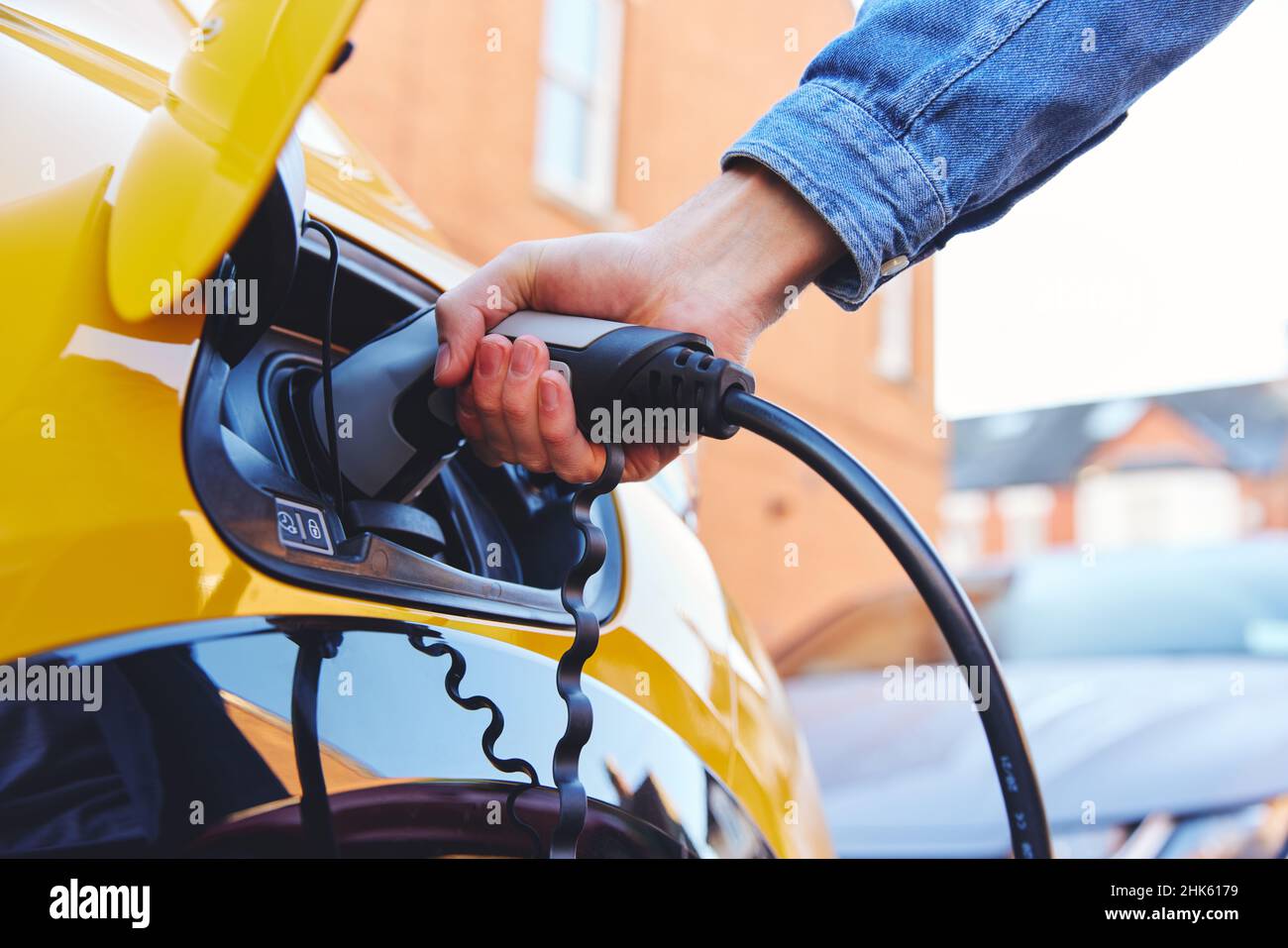 Electric car plugged in outside house on street Stock Photo - Alamy