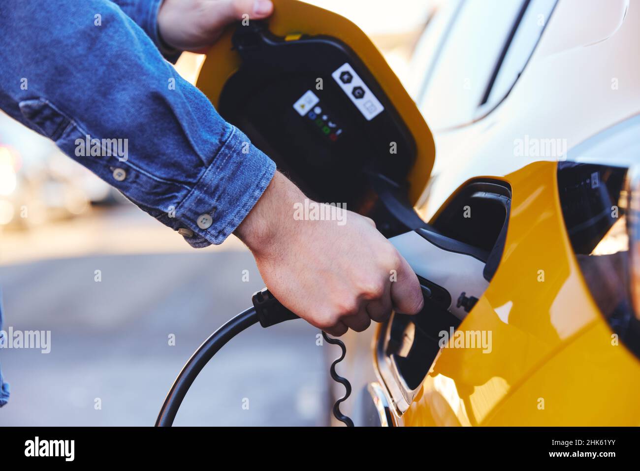 Electric car plugged in outside house on street Stock Photo - Alamy