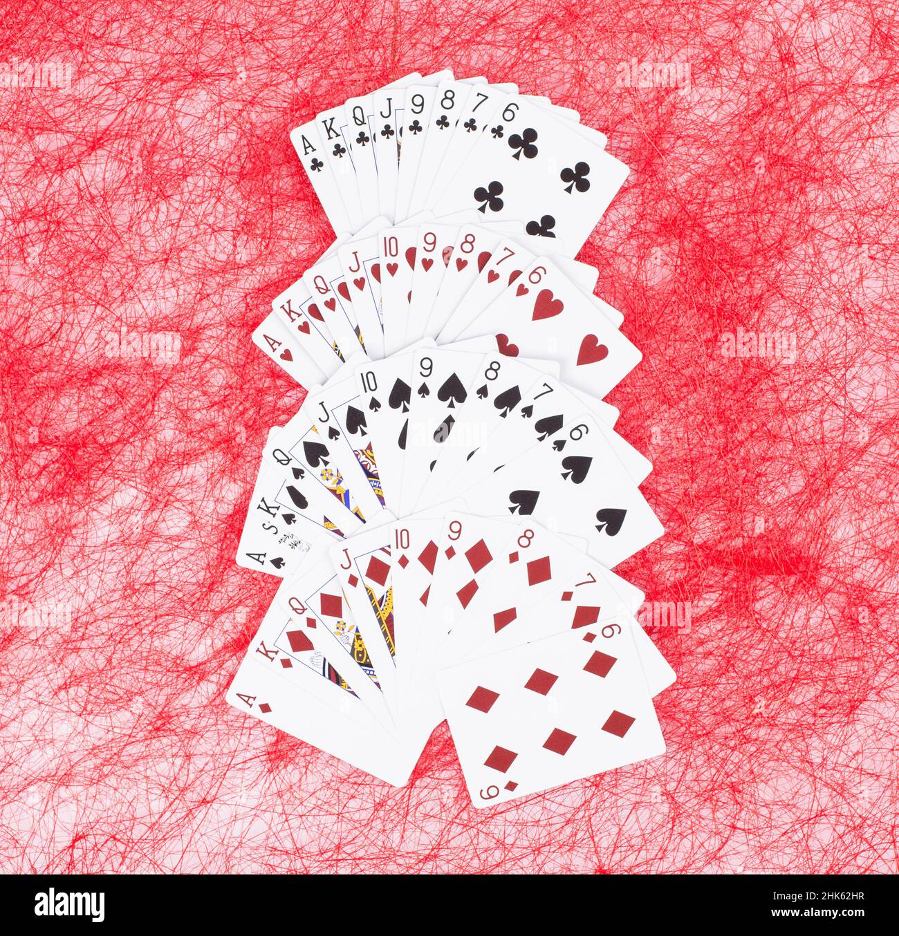 New unpacked playing cards. Located on a red background Stock Photo - Alamy