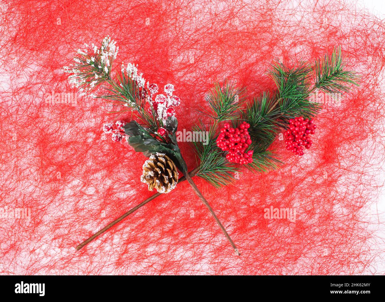 Christmas artificial branch closeup. Located on a red fluff background ...