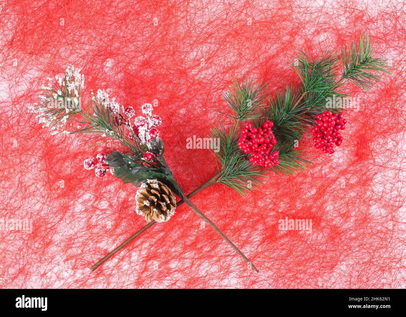 Christmas artificial branch closeup. Located on a red fluff background ...