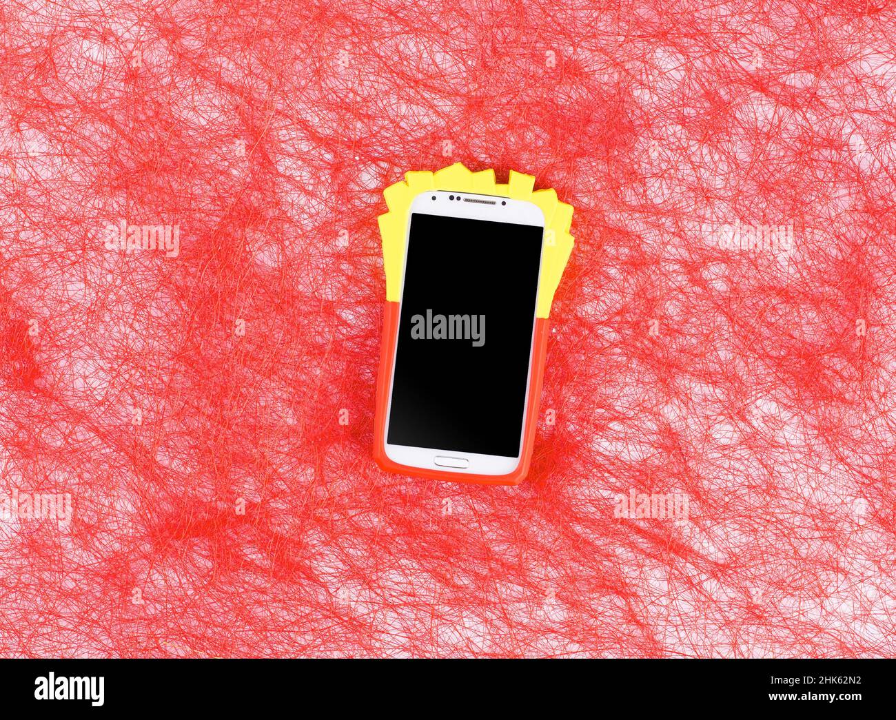Smartphone in fun cover. Located on a red fluff background Stock Photo ...